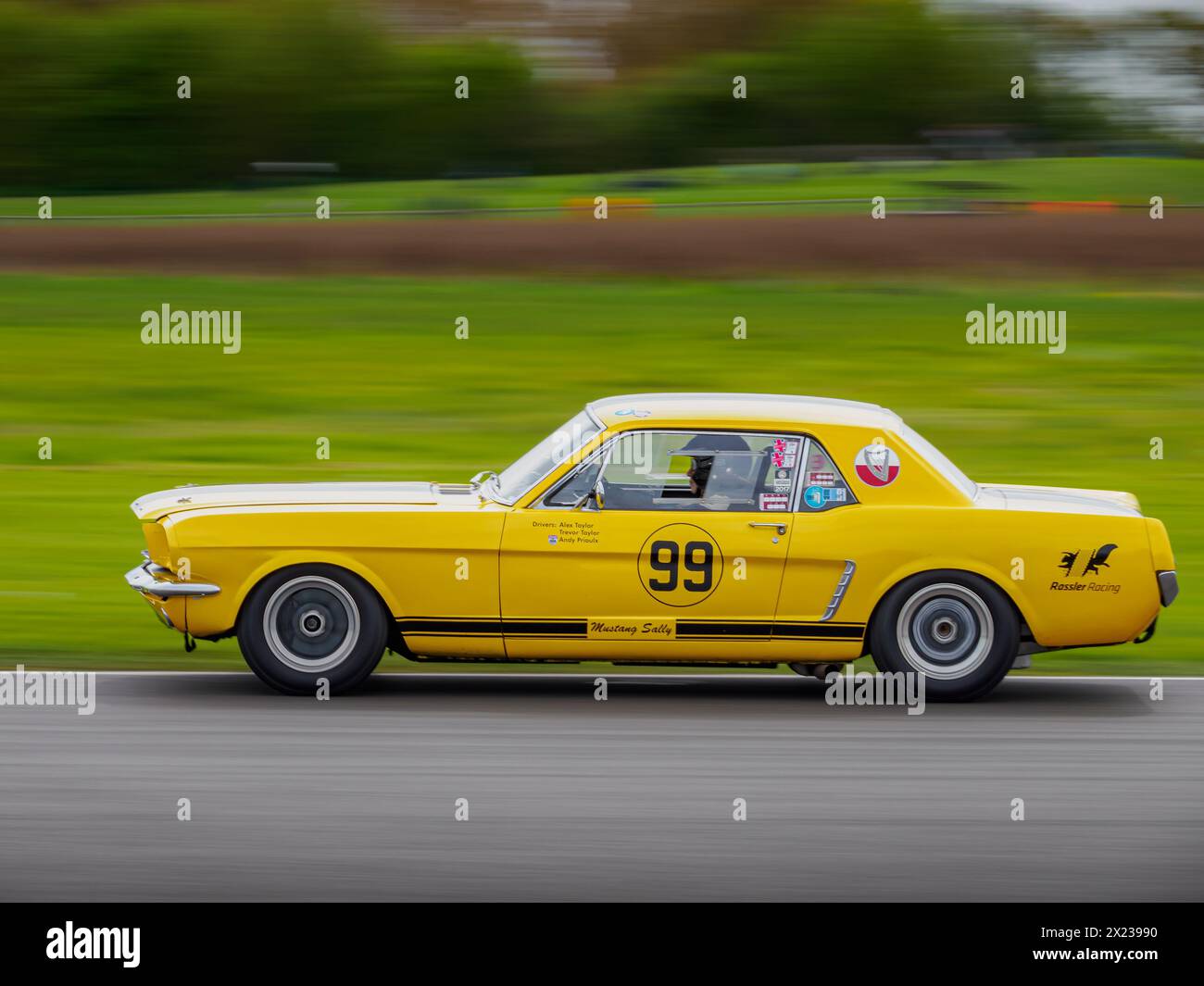 A yellow 1965 Ford Mustang (Mustang Sally) racing in the Ken Miles Cup ...