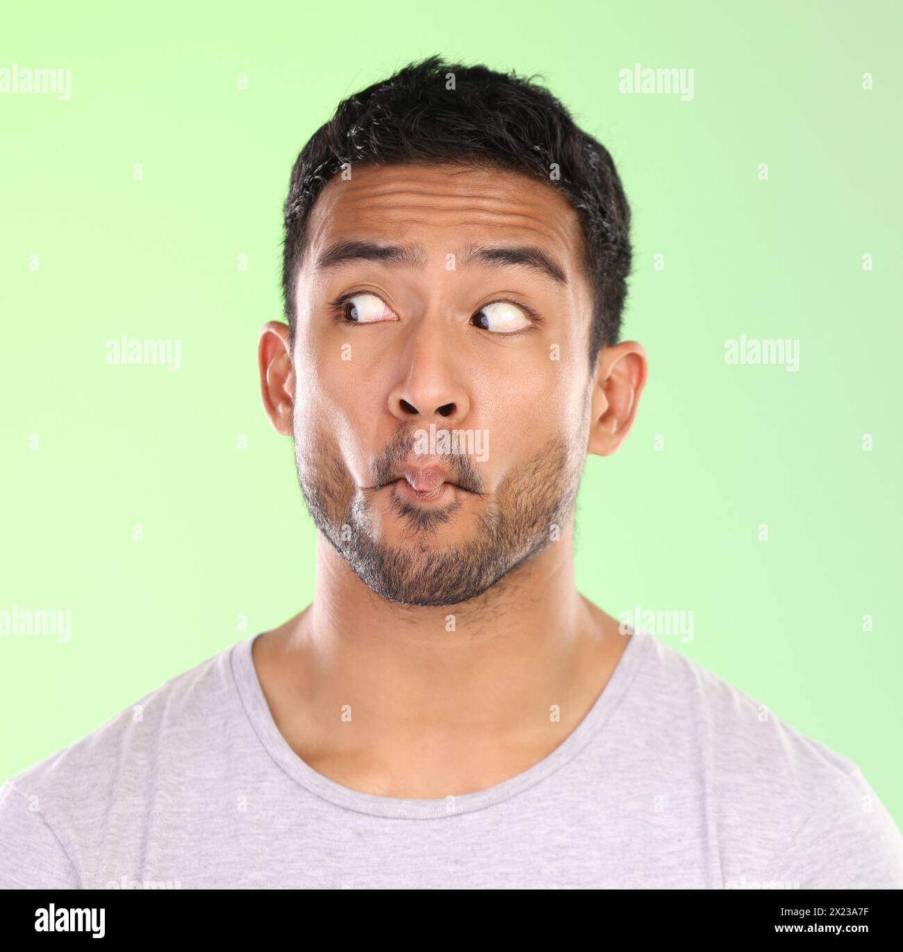 Thinking, crazy and face of funny man in studio with pastel green ...