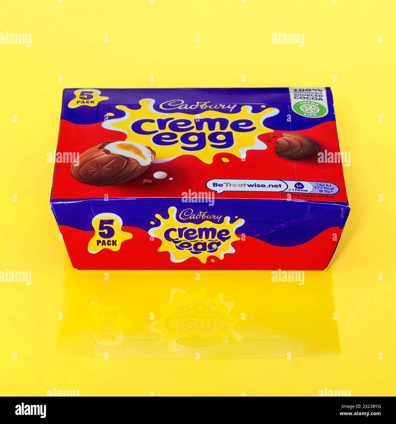 Box of Cadbury Creme Eggs on yellow background with partial reflection ...