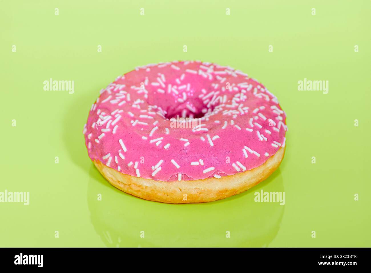 Pink iced Ring Doughnut on light green background with sprinkles on ...