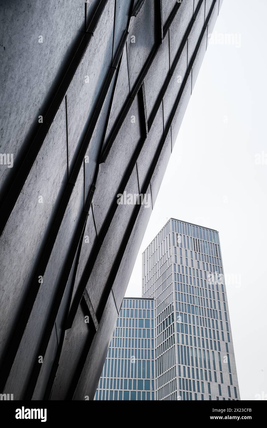 A tall building with numerous windows stands next to another building ...
