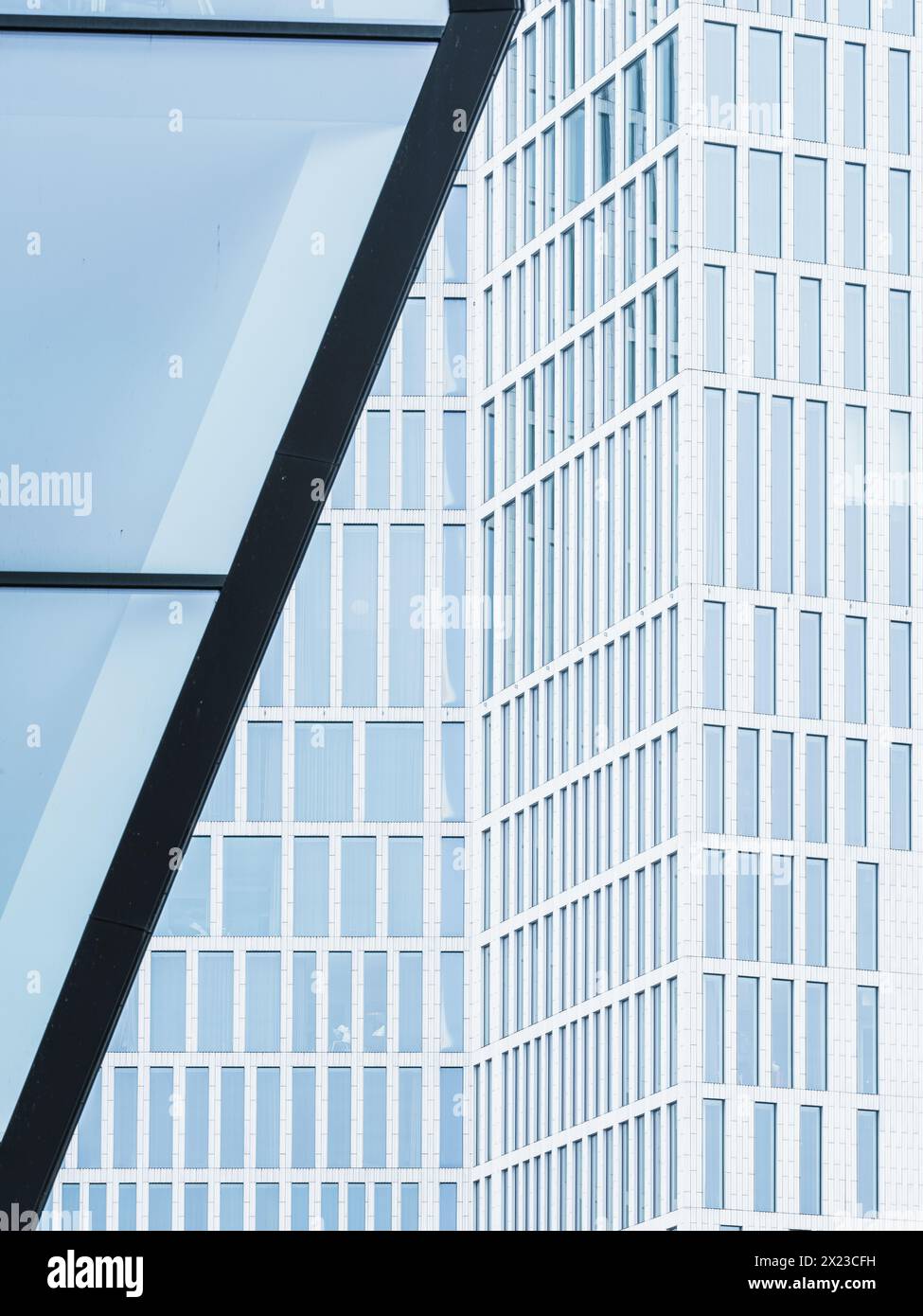 A tall building with numerous windows stands next to another building ...