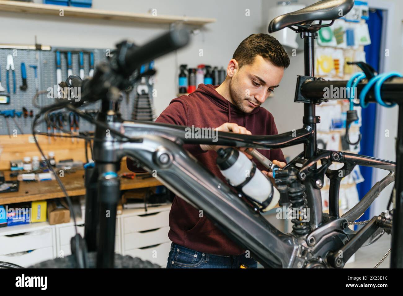 Bike mechanic manipulates the suspension system of an electric mountain ...