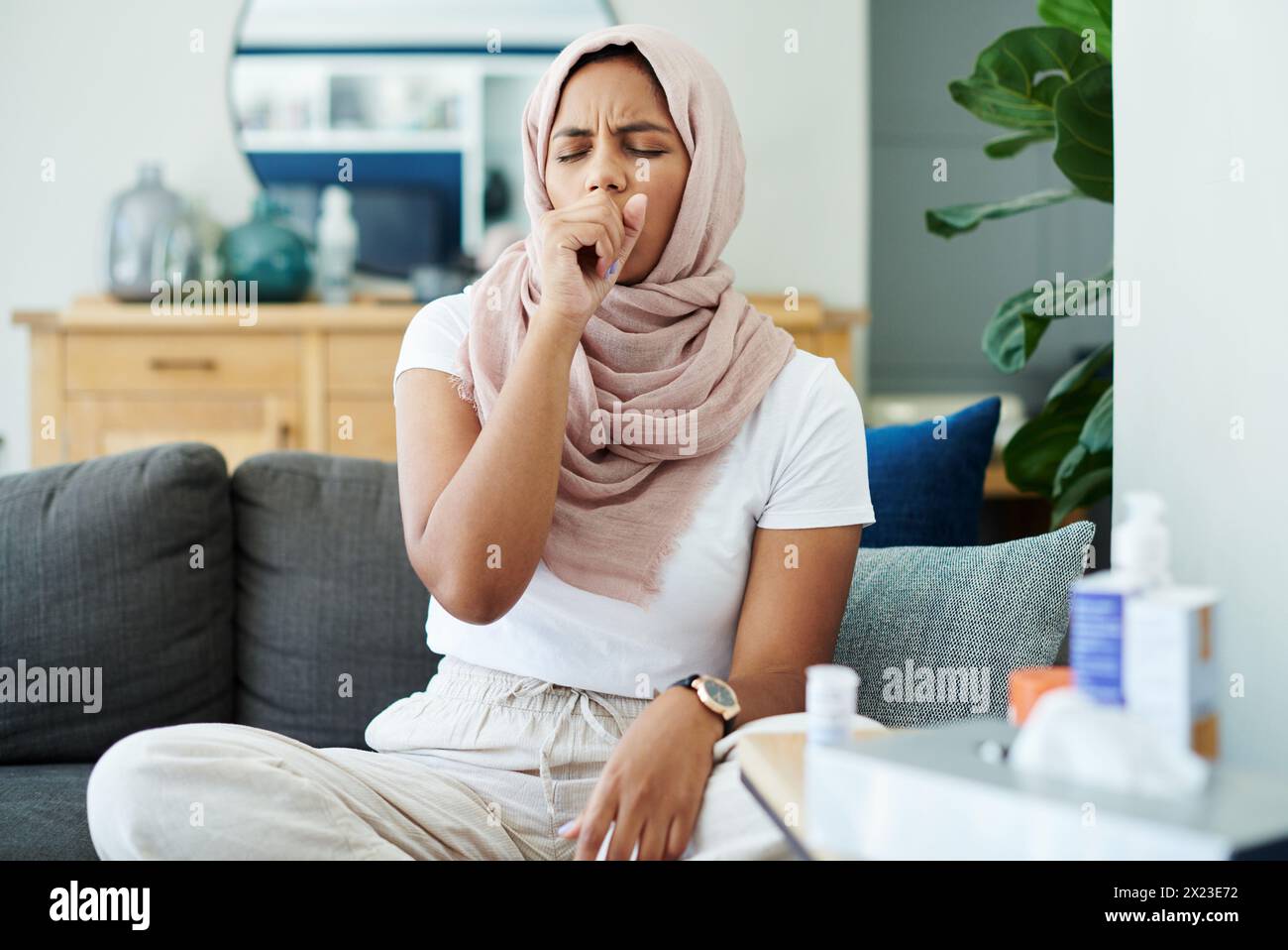 Muslim, woman and sick or cough on sofa in living room with illness ...