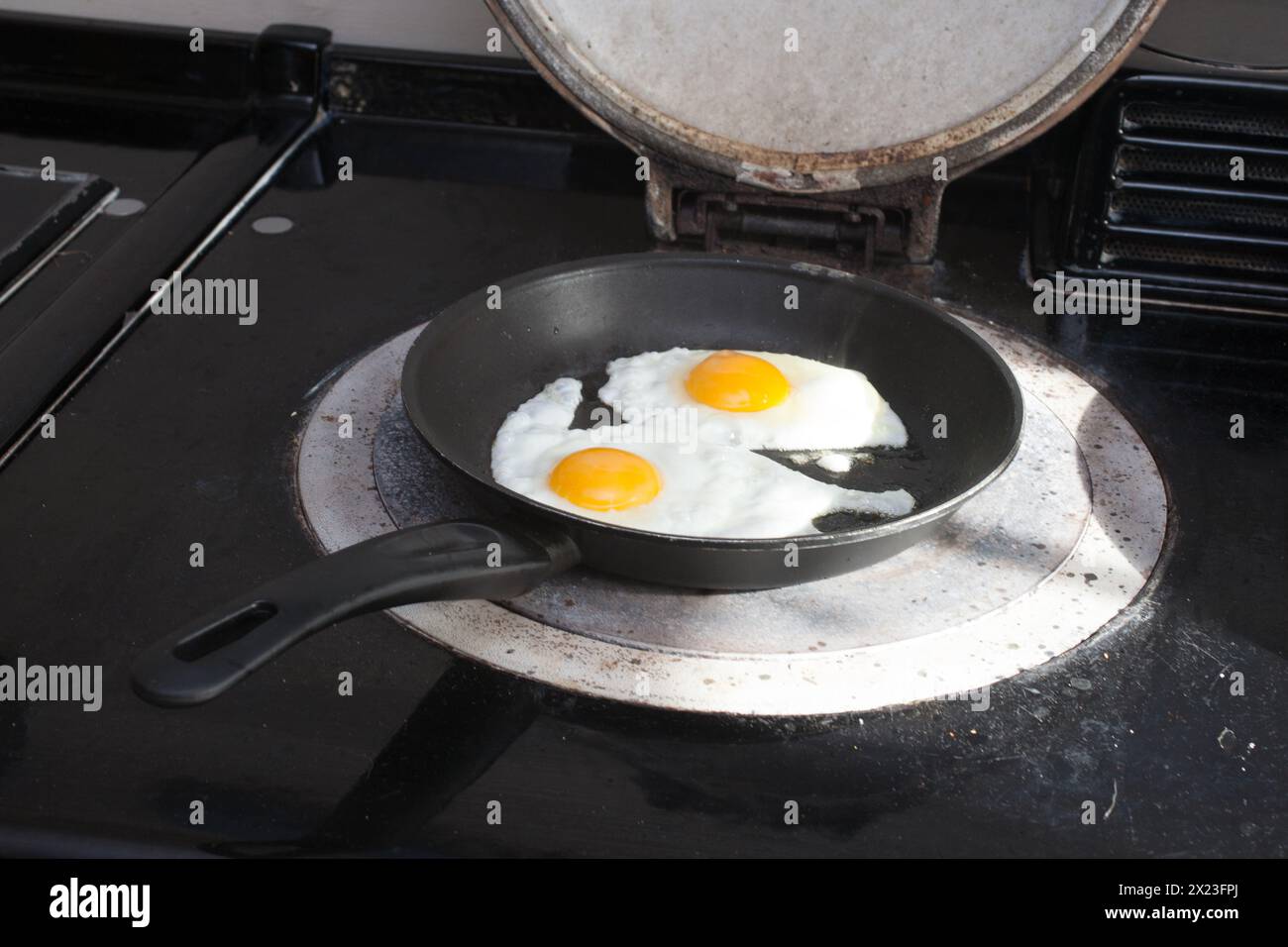 Two hen's eggs frying in a pan on an aga stove Stock Photo - Alamy