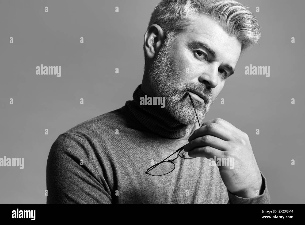 Portrait of handsome man on grey background. Black and white effect ...
