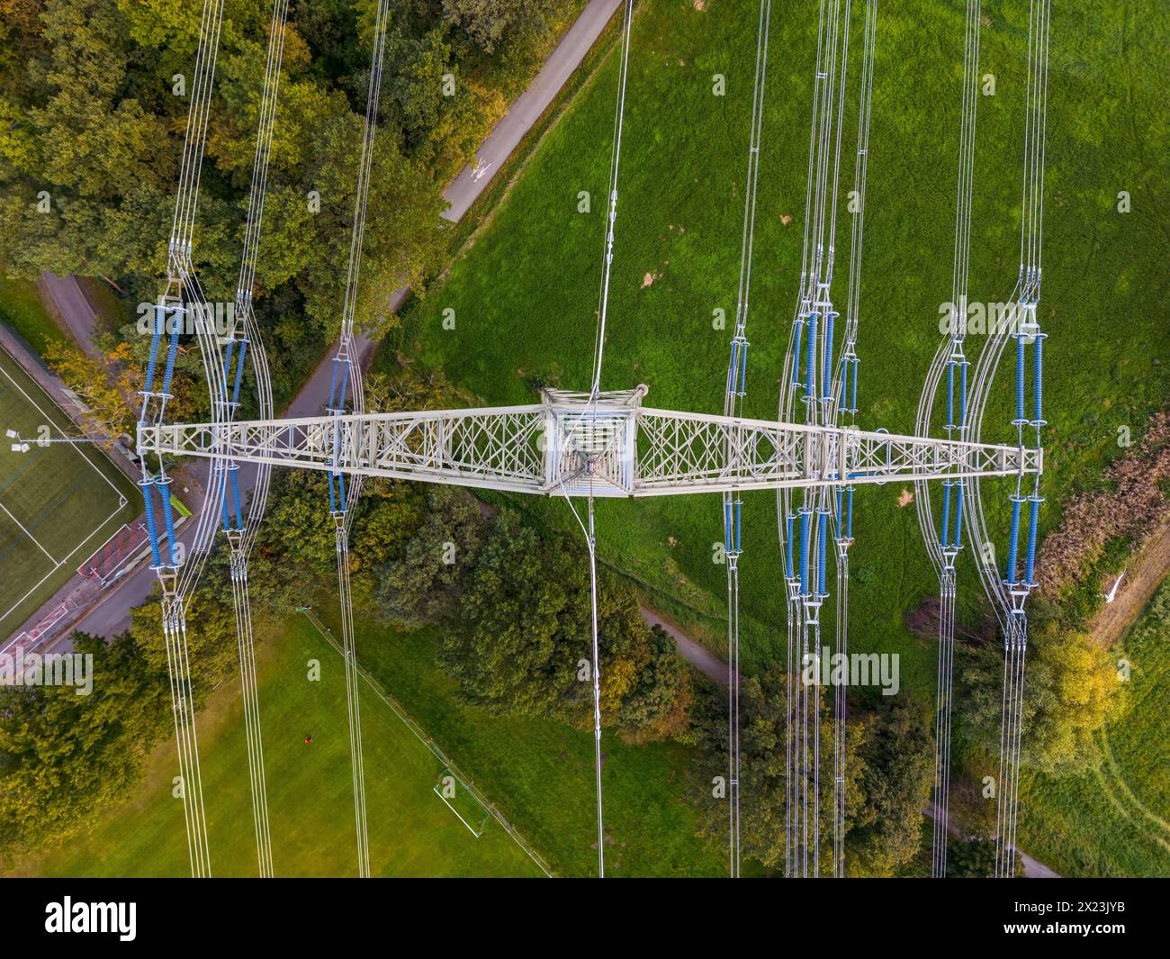 Top shot of a high voltage pylon with power lines in green nature as ...