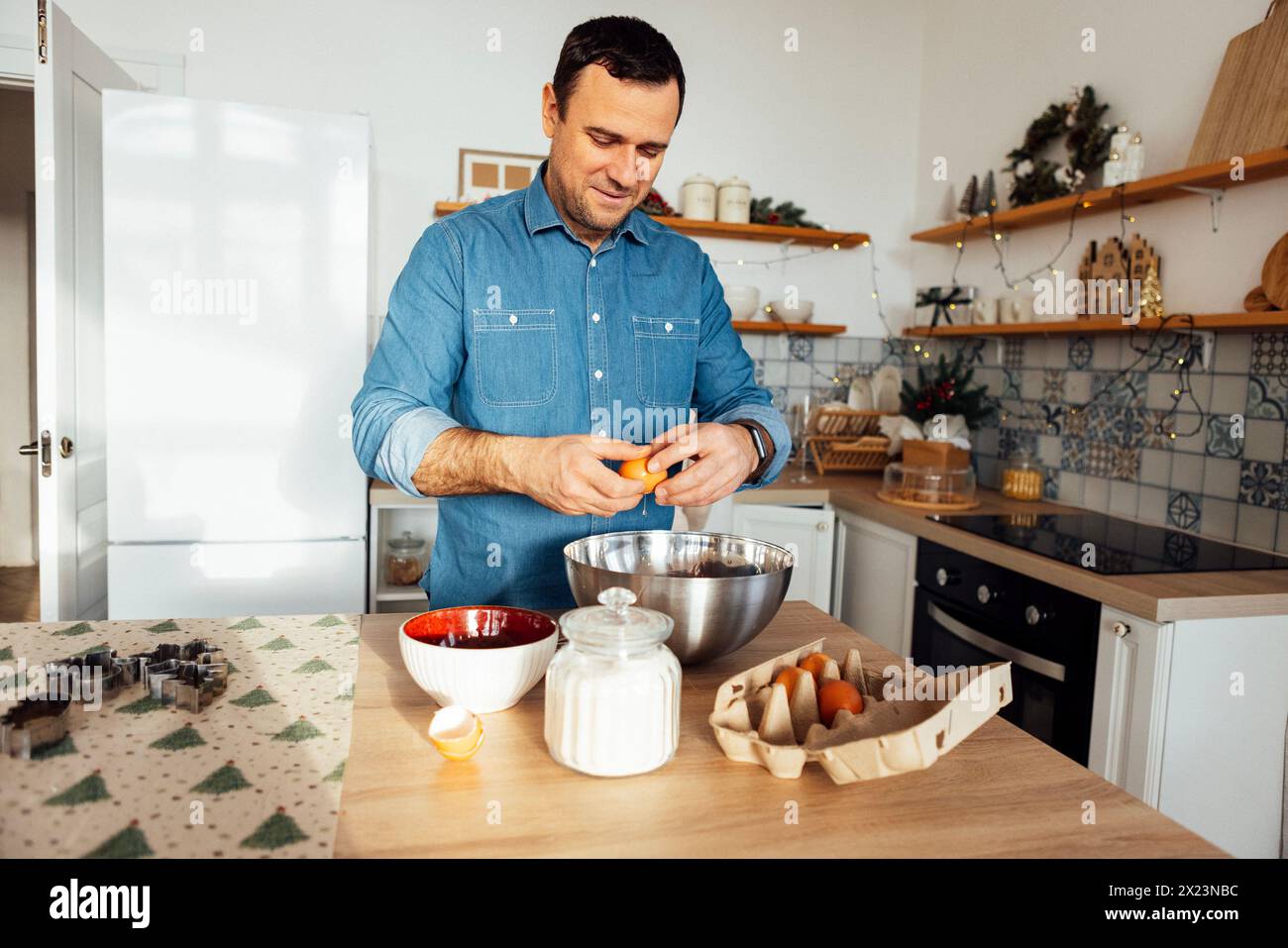 A young handsome man cooks in the kitchen at home. An attractive man ...