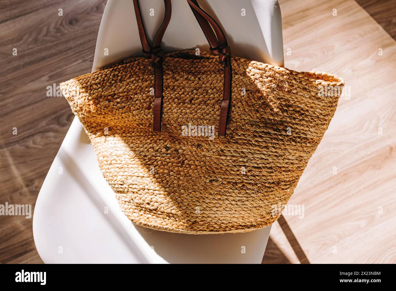 Fashionable summer jute bag standing on the chair in natural light ...