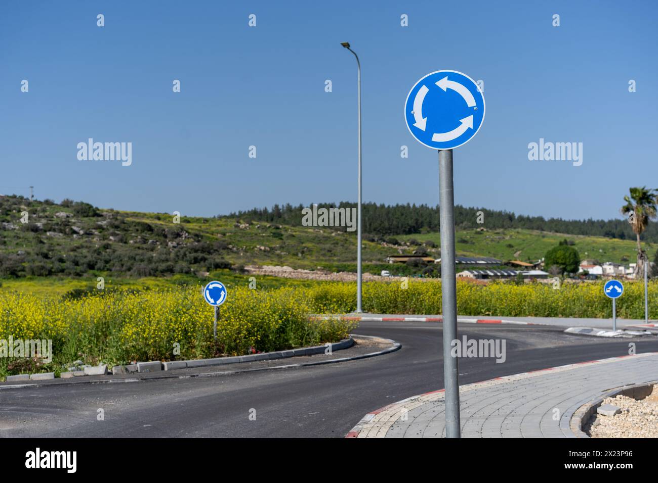 A solitary roundabout traffic sign against a backdrop of a vibrant ...