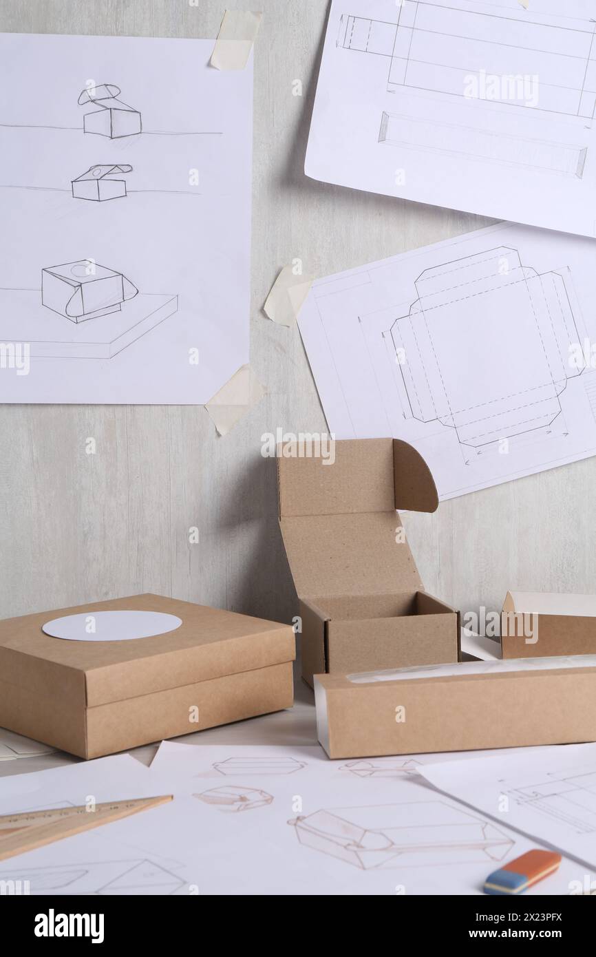 Creating packaging design. Drawings, boxes and stationery on table ...