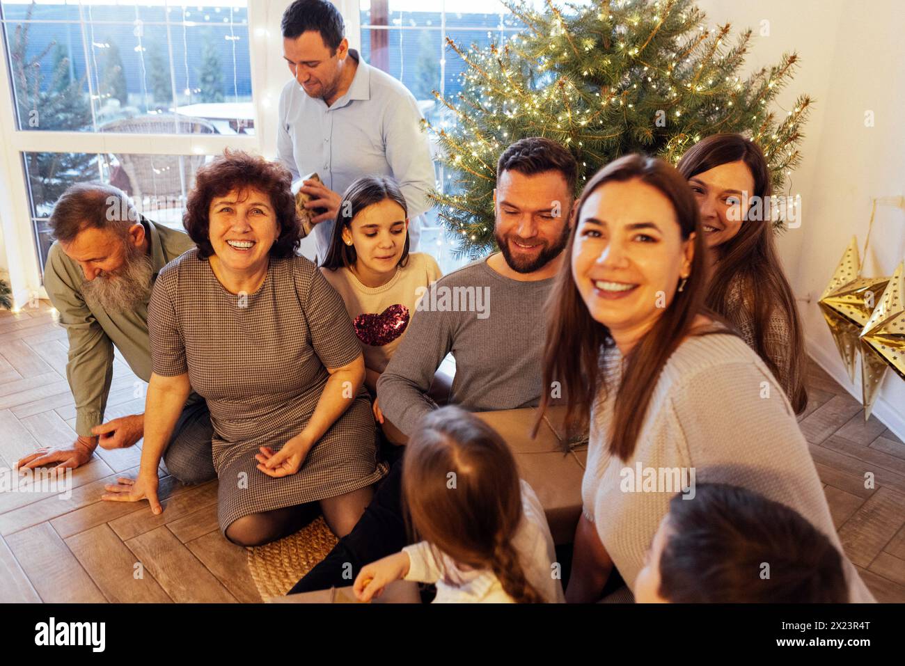 A big happy family gives gifts under the Christmas tree at home ...