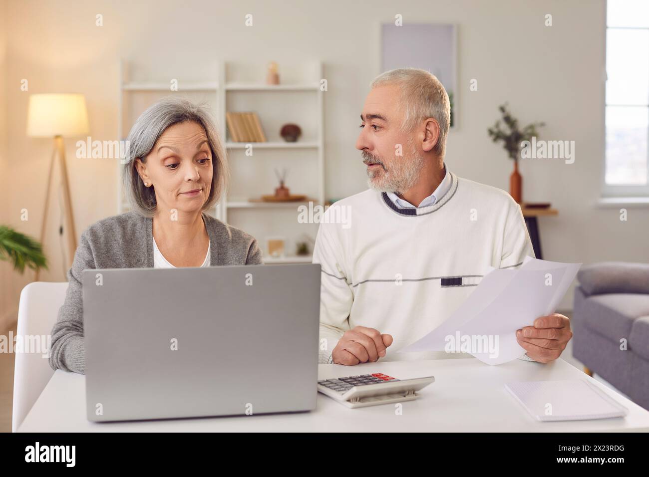 Senior couple calculating payment online, watching laptop screen ...
