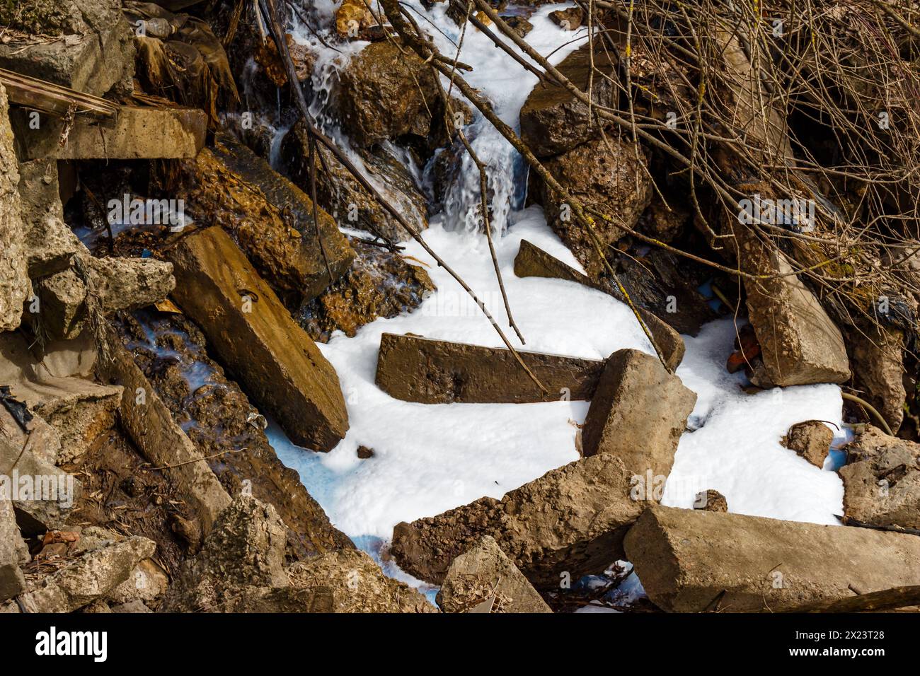 Illegal drainage of technical fluid into a ravine forming white foam ...