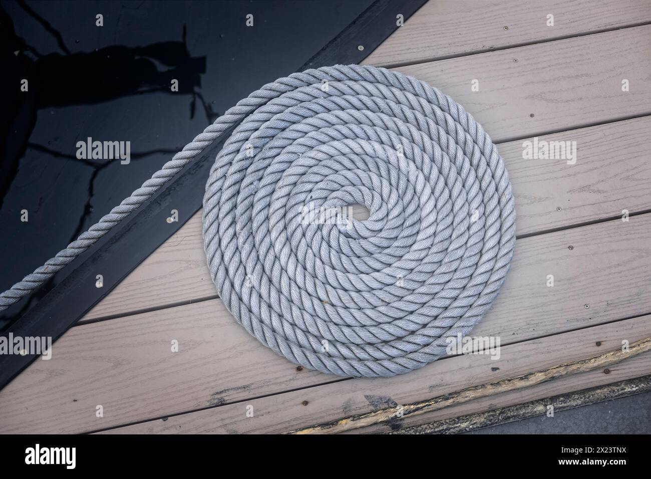 A coil of rope lies neatly stowed on a dock Stock Photo - Alamy