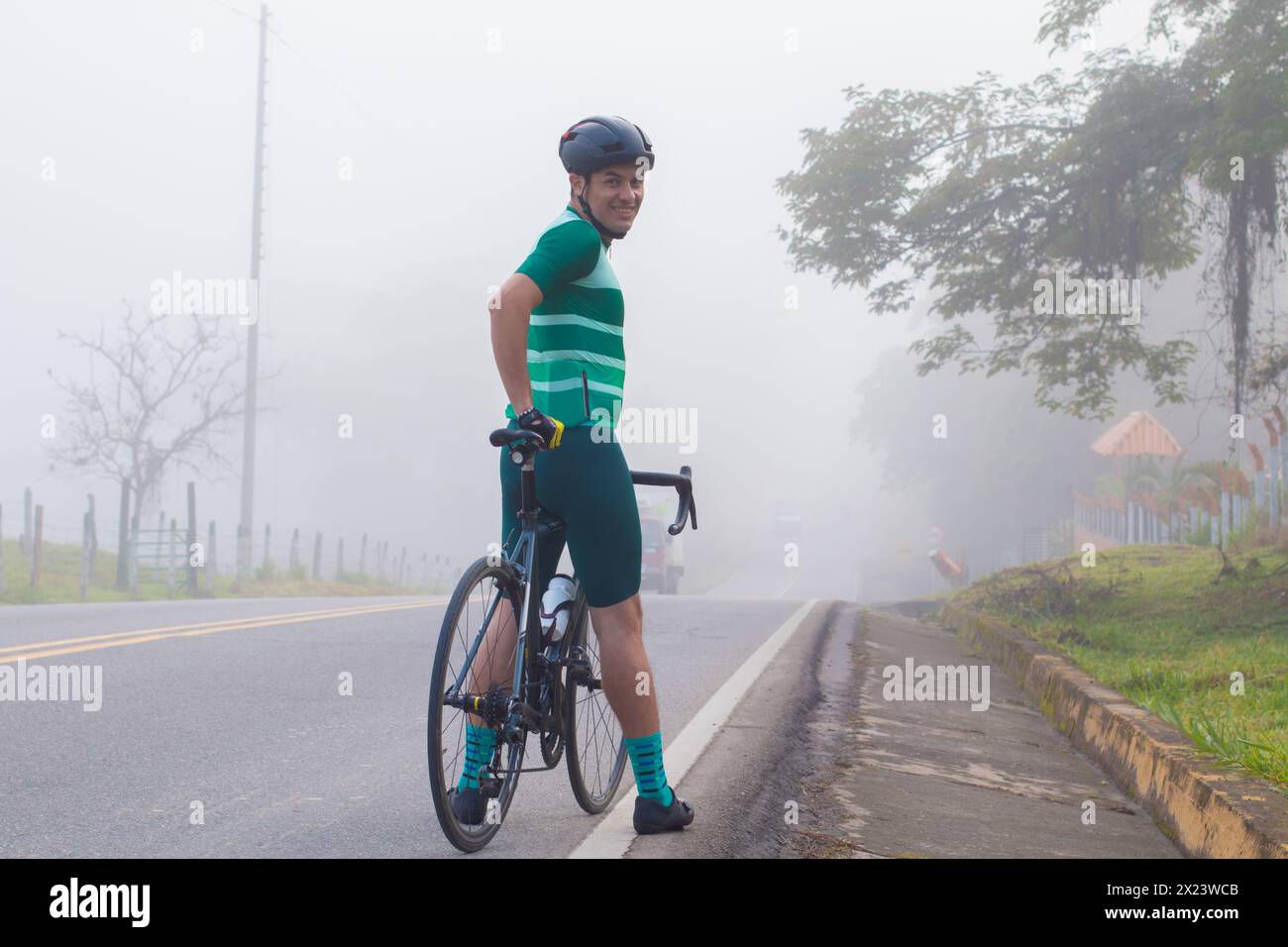 lifestyle and sport concept, cyclist on road looking back. complete ...