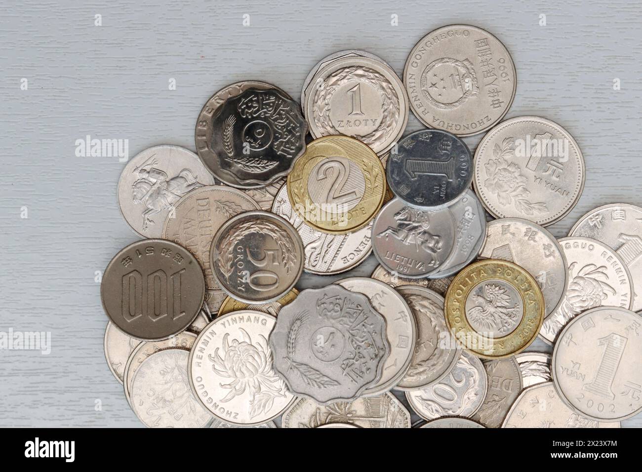 Vertical photo of a variety of metal coins on a light background, top ...