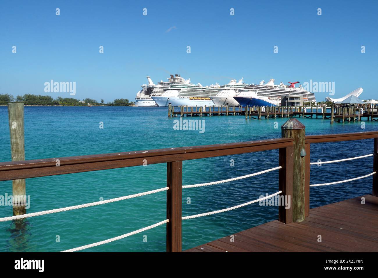 Four large cruise passenger ships observed from a wooden pier in Nassau ...