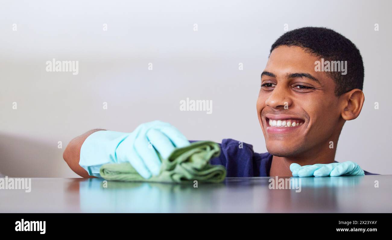 Young man, smile and cleaning a kitchen counter, housekeeping and ...