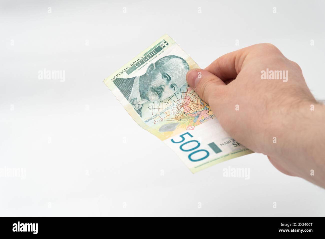 Man holding pile of money 500 RSD Serbian Dinar banknote paper currency ...