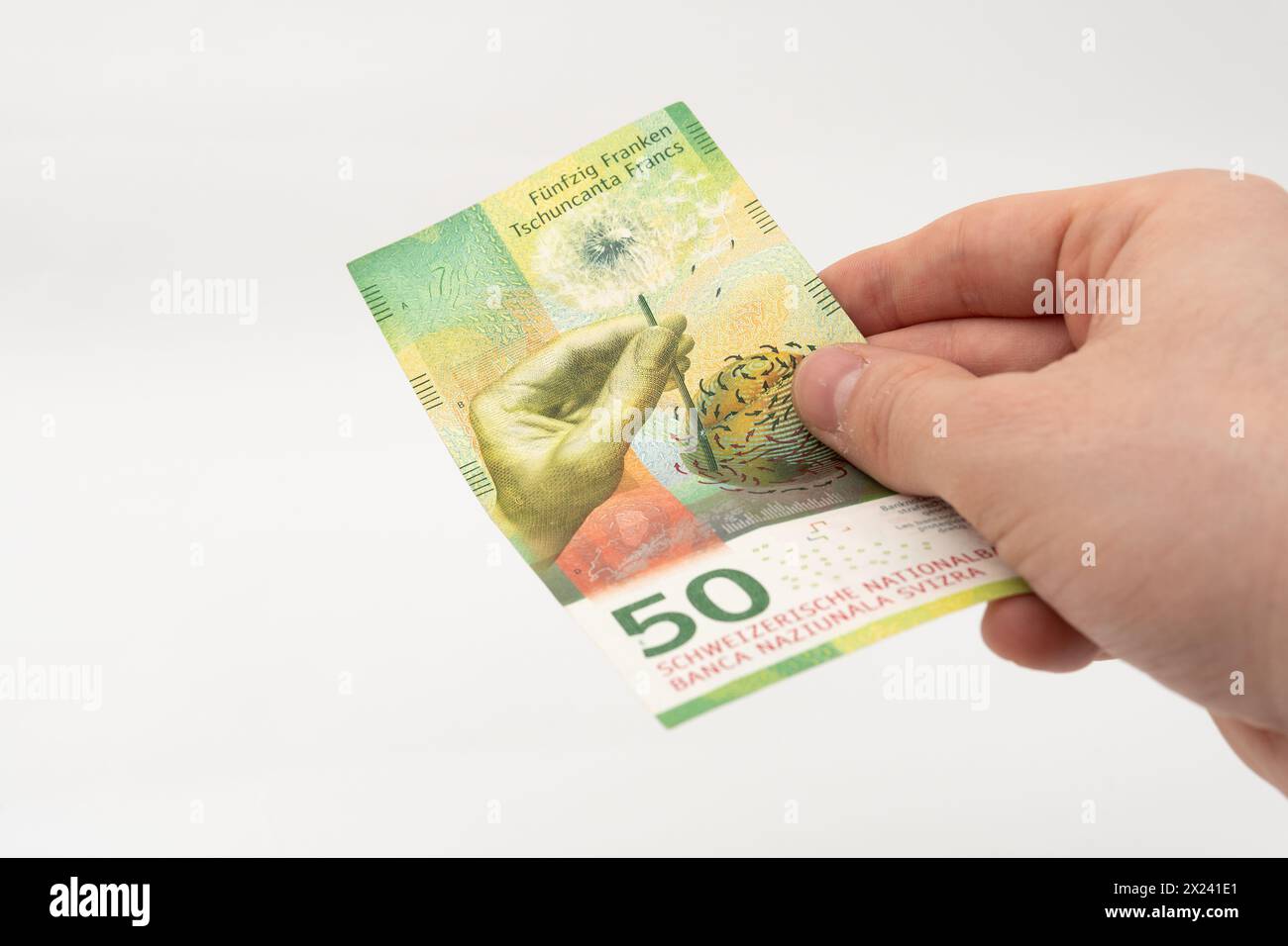 Man holding 50 CHF Swiss franc banknote paper currency isolated on ...