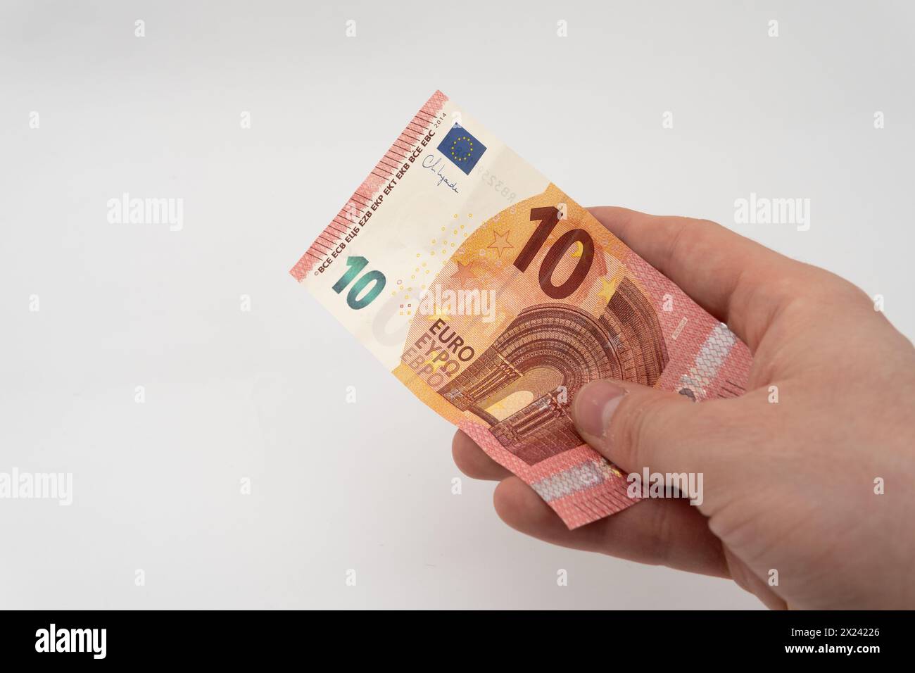 Man holding 10 EUR banknote paper currency Euro isolated on white ...
