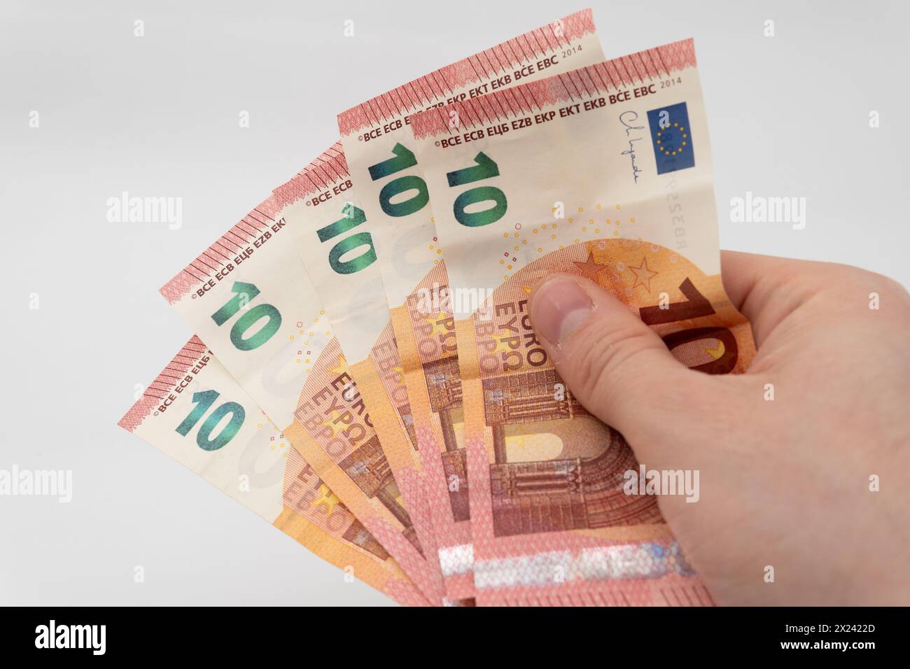 Man holding pile of money 10 EUR banknote paper currency isolated on ...