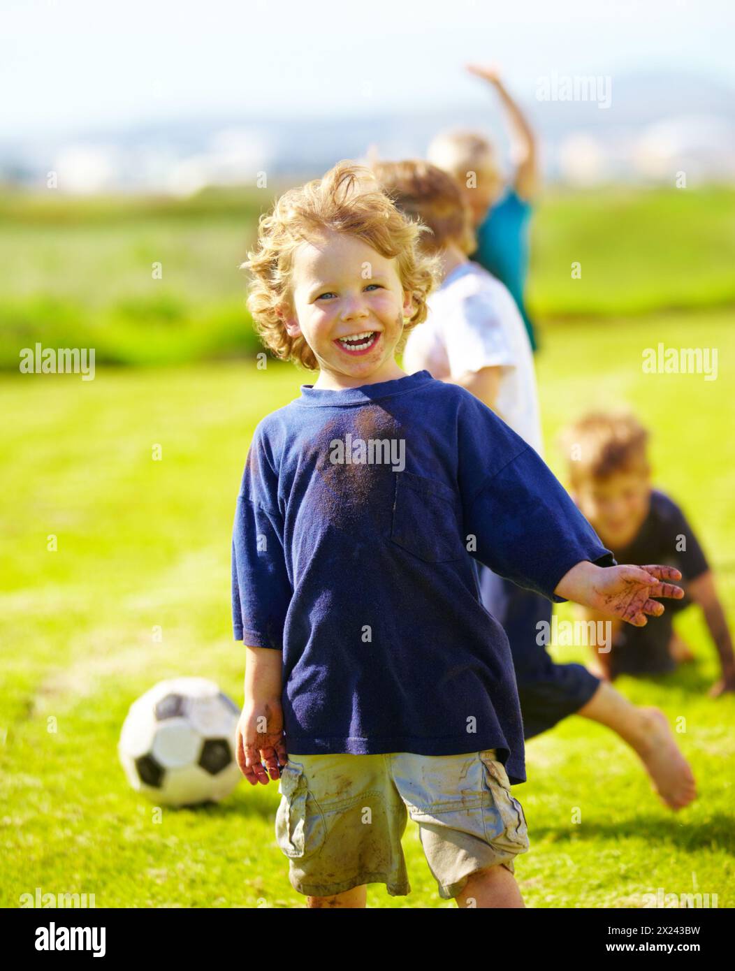 Dirt, smile and portrait of child for soccer by grass, lawn and outdoor ...