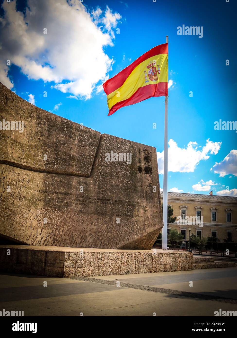 panish flag waving in the wind in a blue sky with clouds at Plaza de ...