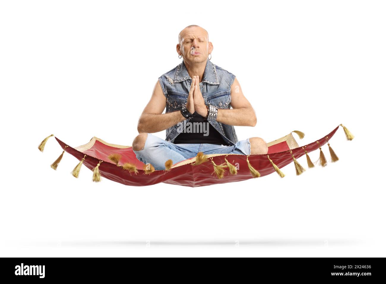 Bald man sitting on a magic carpet and meditating isolated on white ...