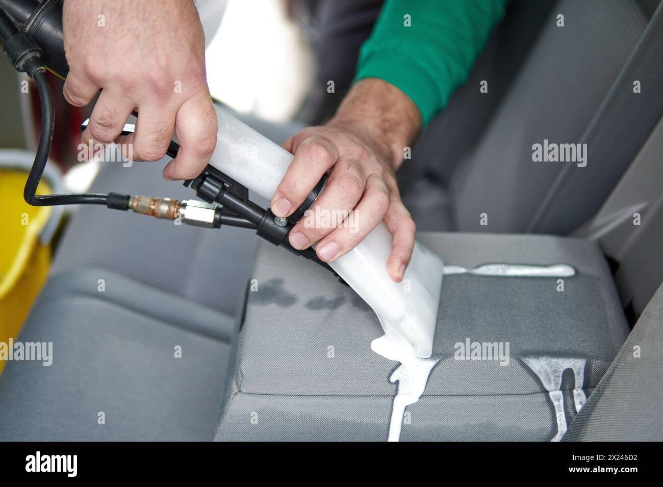 Car cleaning detailing - male using professional steam vacuum chemical ...