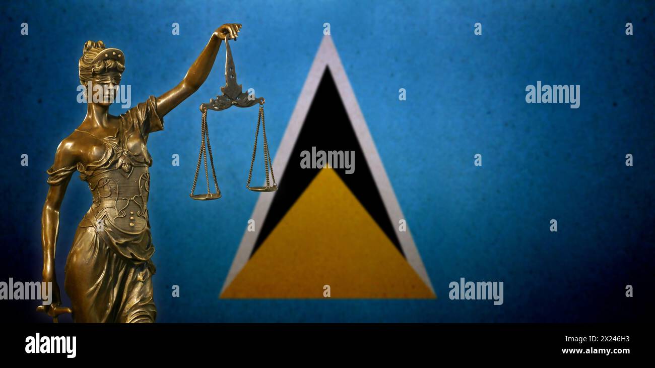 Close-up of a small bronze statuette of Lady Justice before a flag of ...