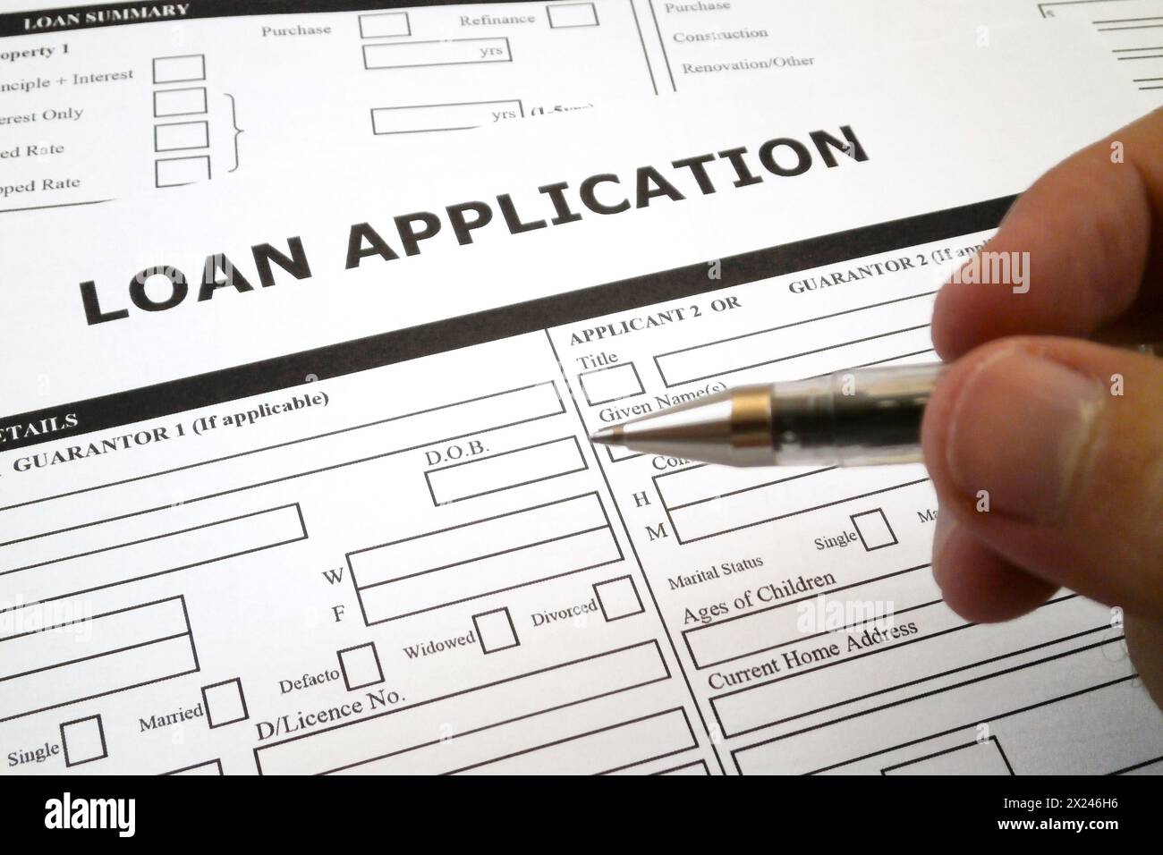 Pen hold by a fingers of somebody ready to fill a loan application form ...