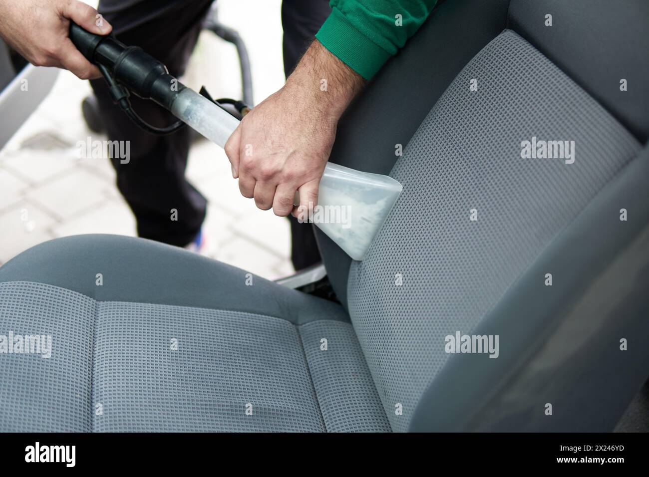 Car cleaning detailing - male using professional steam vacuum chemical ...