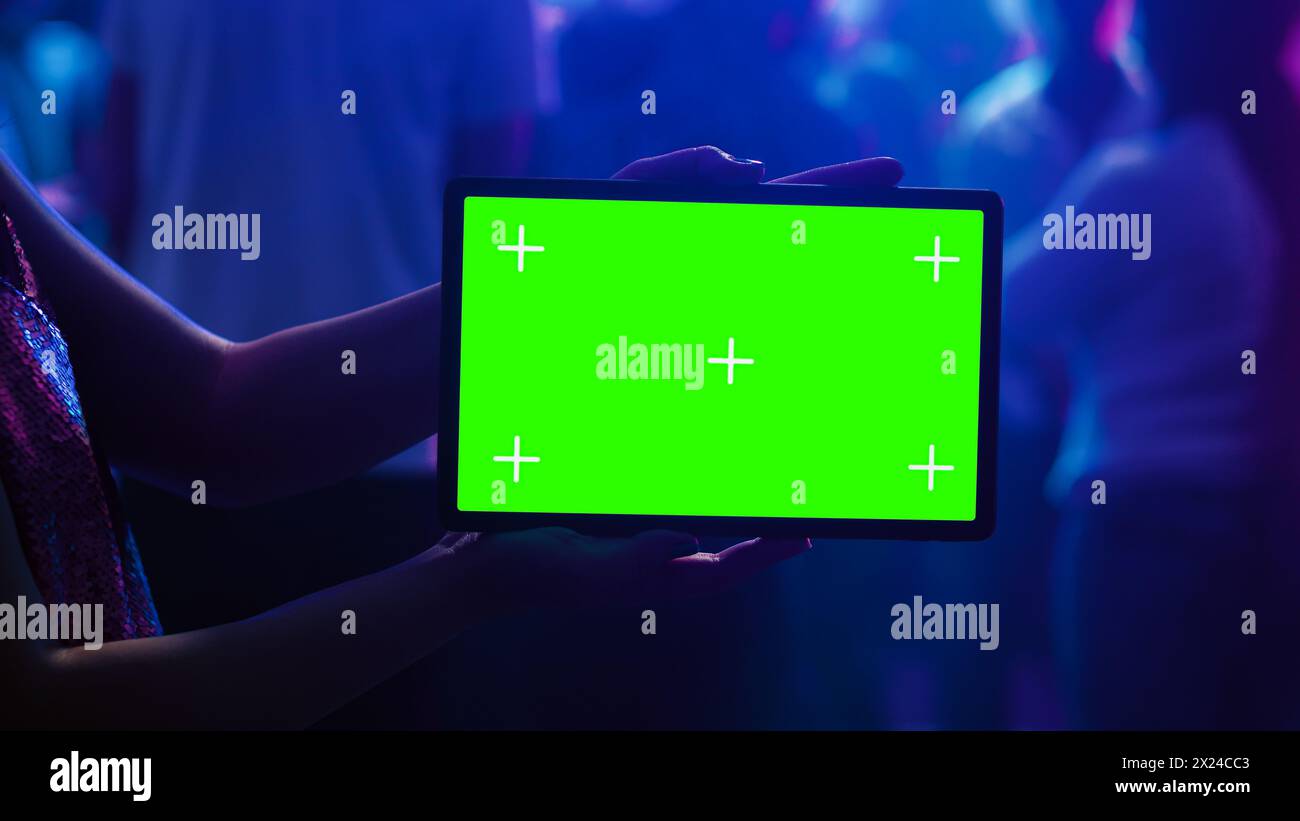 Adult using tablet with green screen at club, holding gadget with blank ...