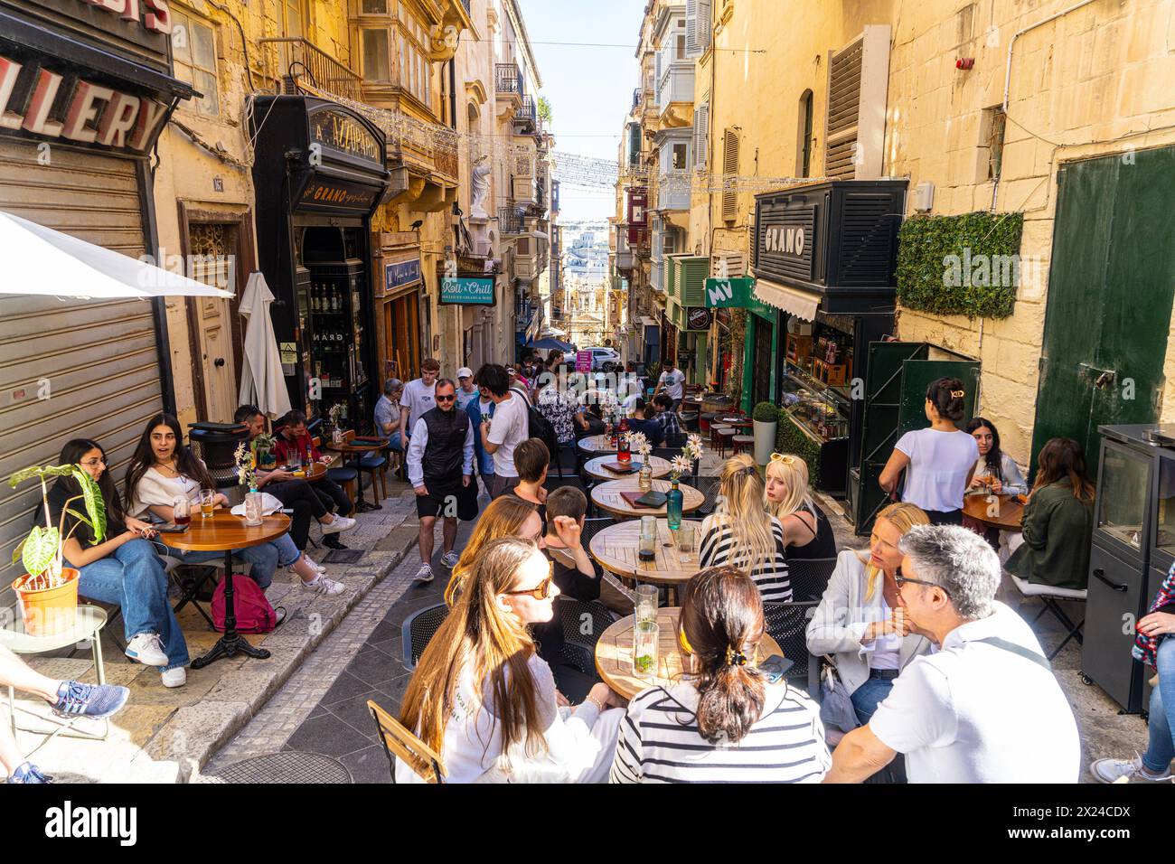 Valletta, Malta, April 03, 2024. tourists sitting between the tables of ...