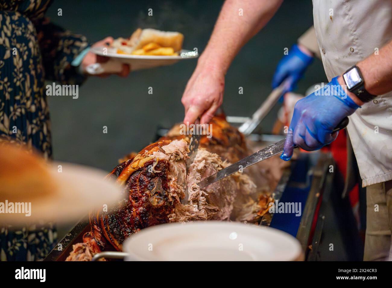 Male chef carving a hog roast Stock Photo - Alamy