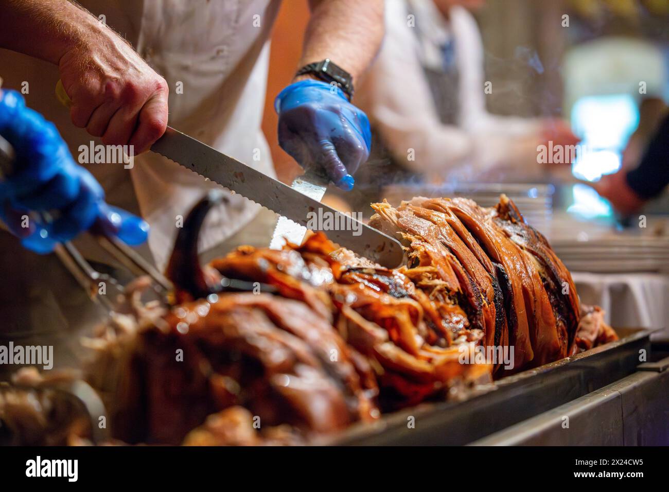 Male chef carving a hog roast Stock Photo - Alamy