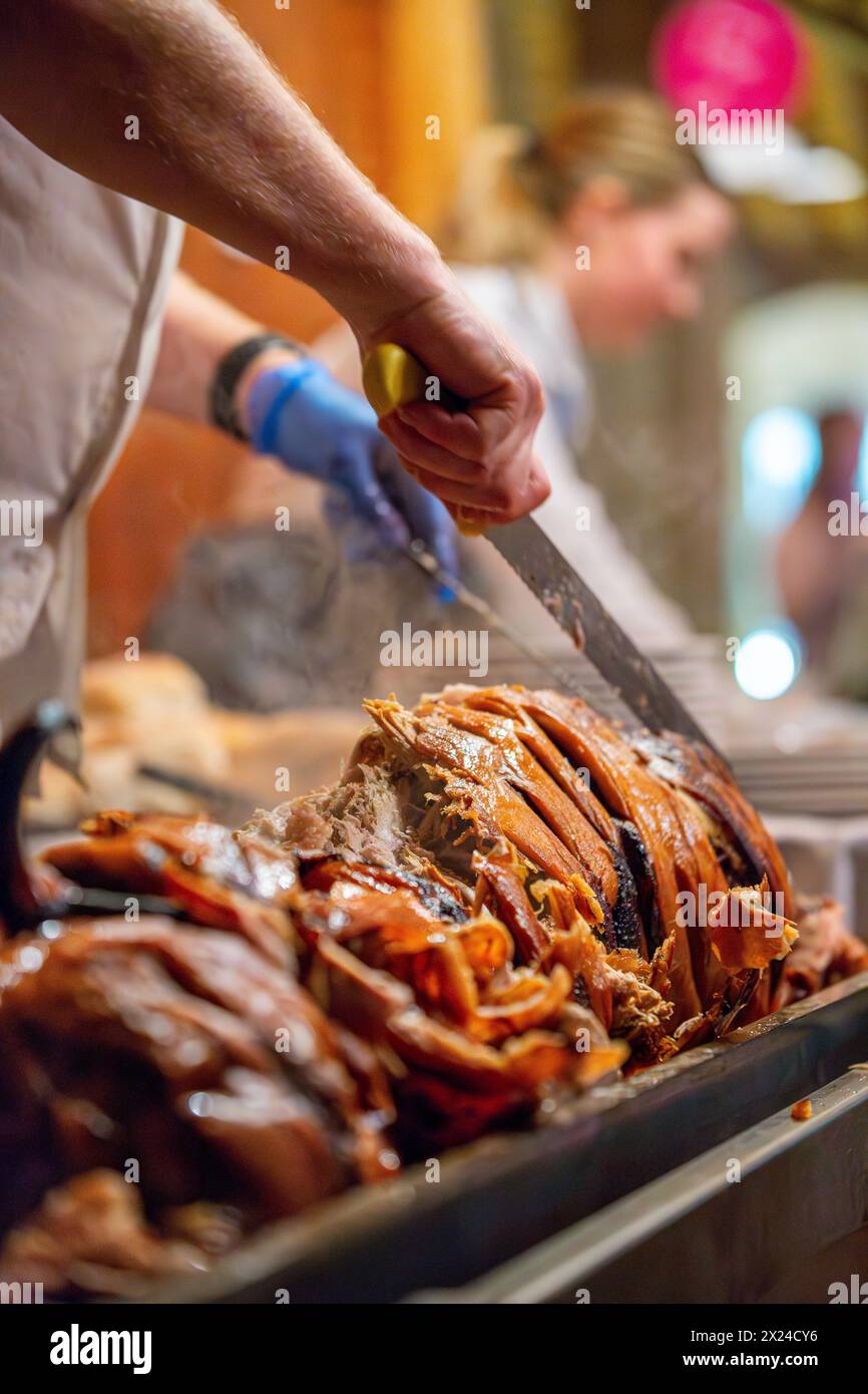 Male chef carving a hog roast Stock Photo - Alamy