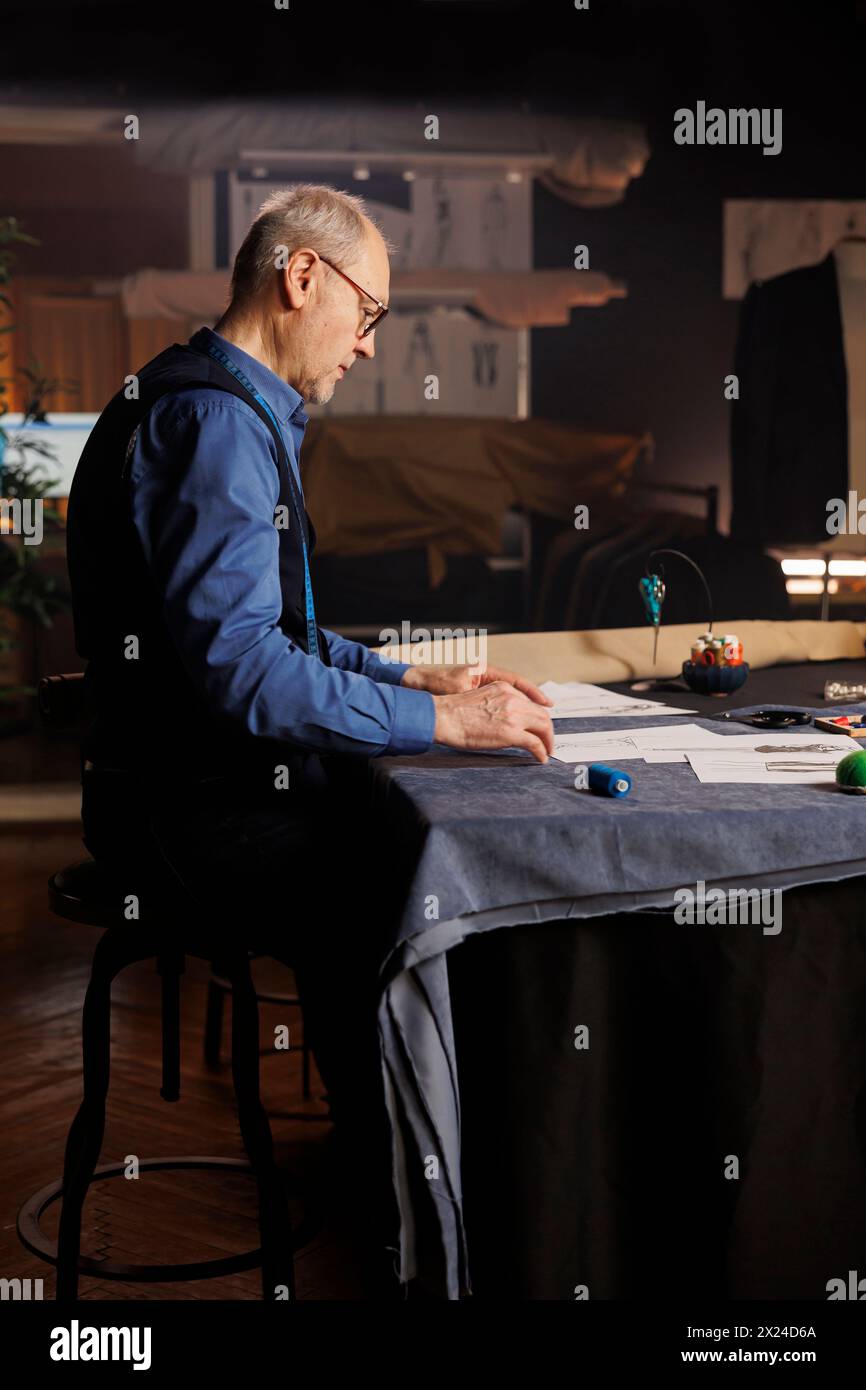 Fashion designer working on upcoming sartorial project for runway show ...