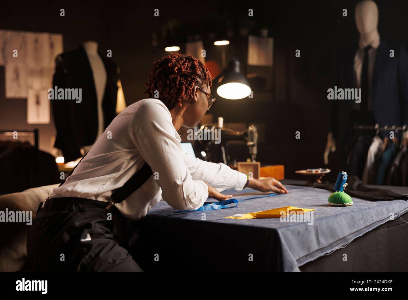 Experienced tailor doing textile fabric measurements in professional ...