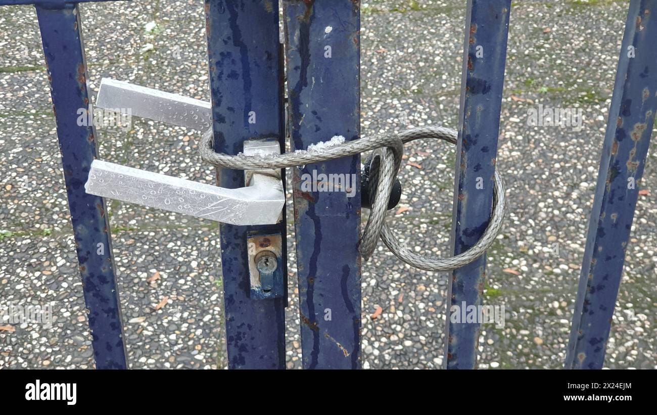 Old blue metal gate with closed lock and chain. Security outside ...