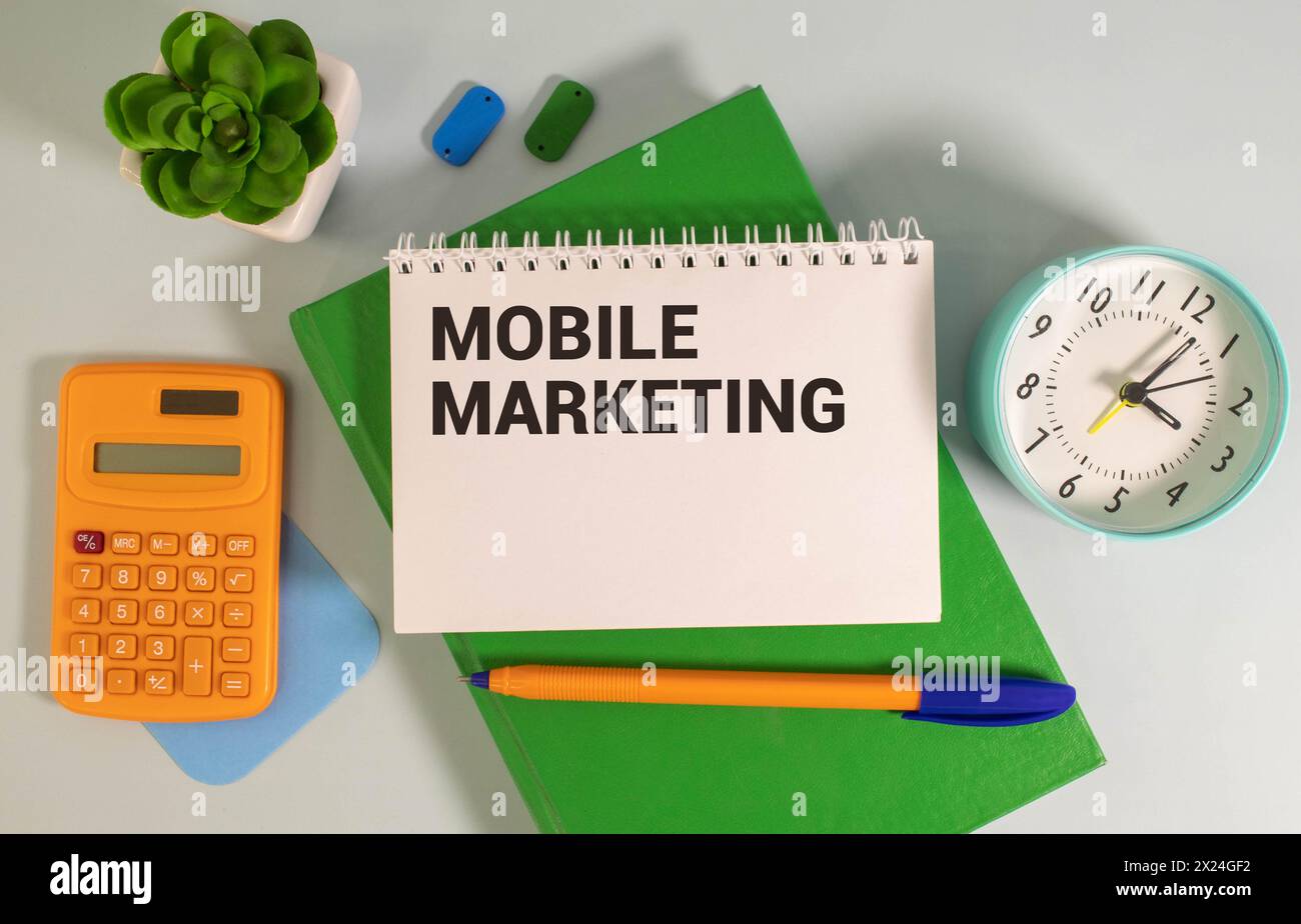 Businessman holds smart phone with mobile marketing words on its screen ...