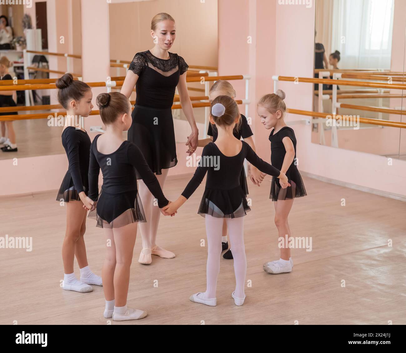 Children's ballet school. Caucasian woman teaching ballet to little ...
