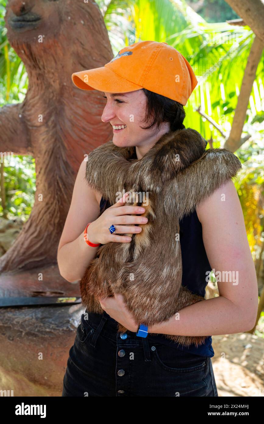 An adult woman holds a three-toed sloth (Bradypus variegatus) at Jungle ...
