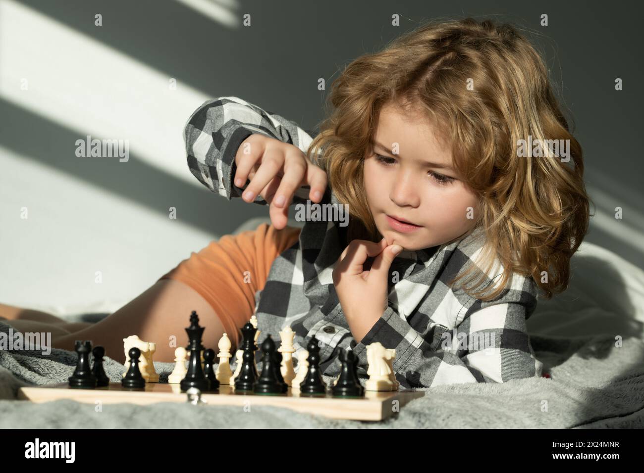 Kid play chess at home. Child thinking near chessboard. Learning and ...