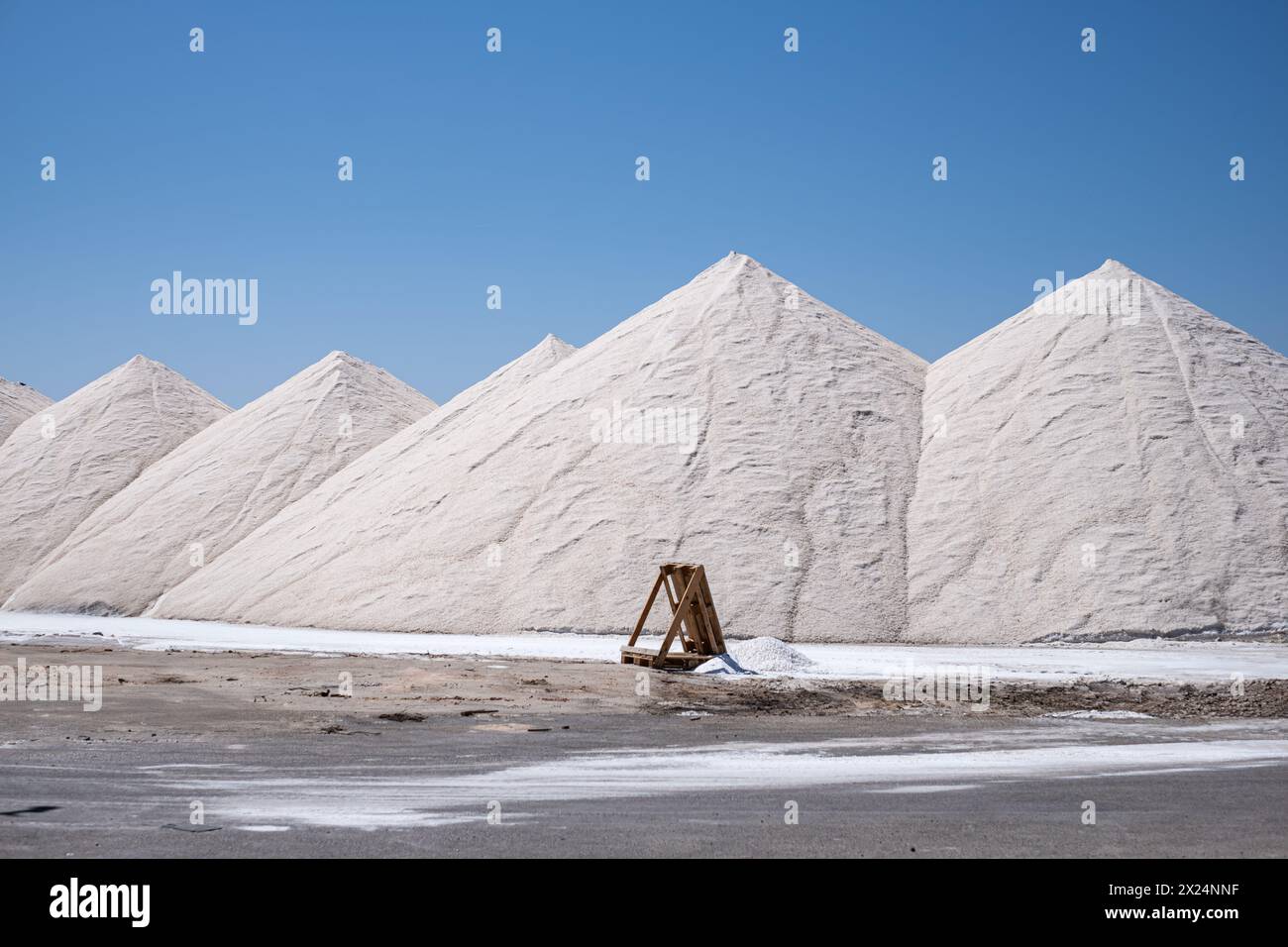 The brilliant white of salt mountains stands out in the bright sunlight ...