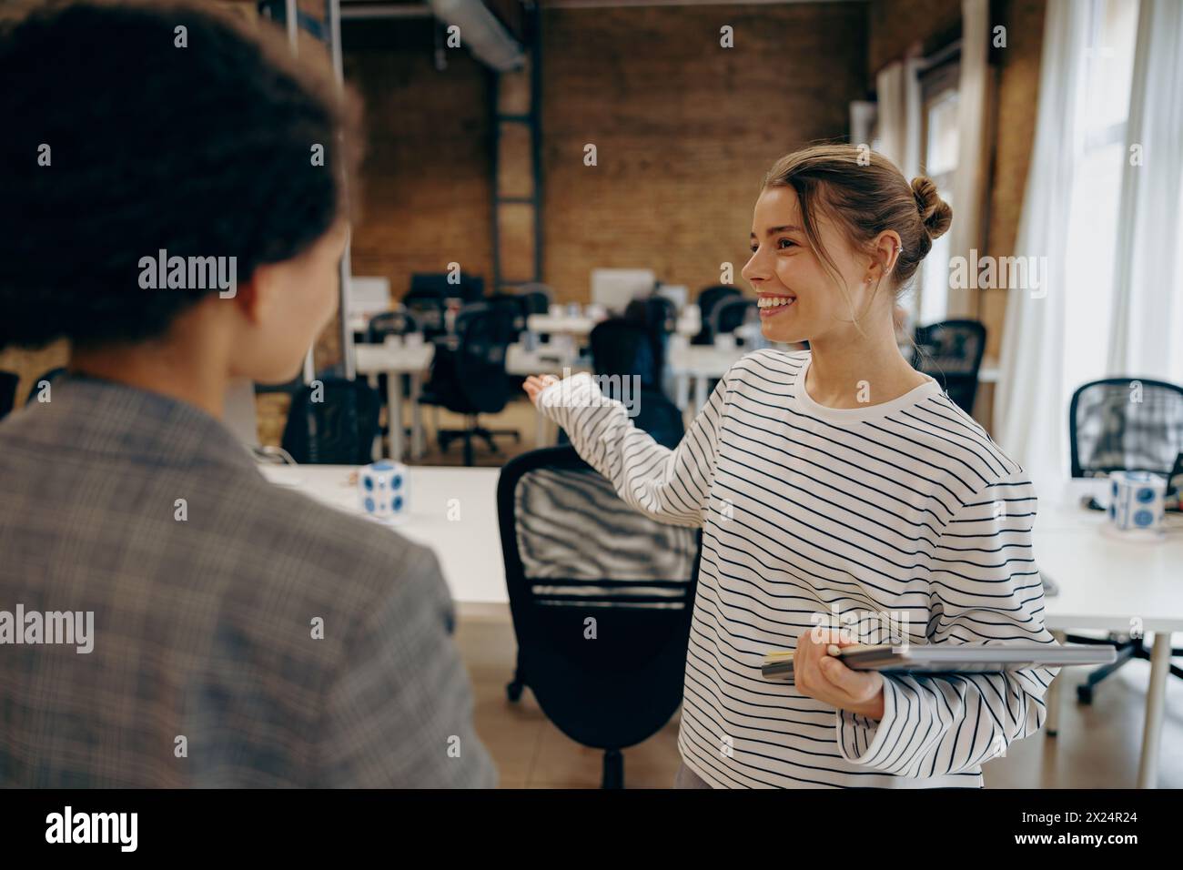 Two female managers met in the office interior and stopped to talking ...