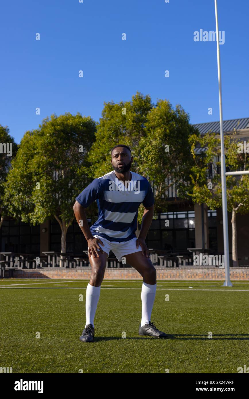 African American young male athlete standing on a rugby field outdoors ...