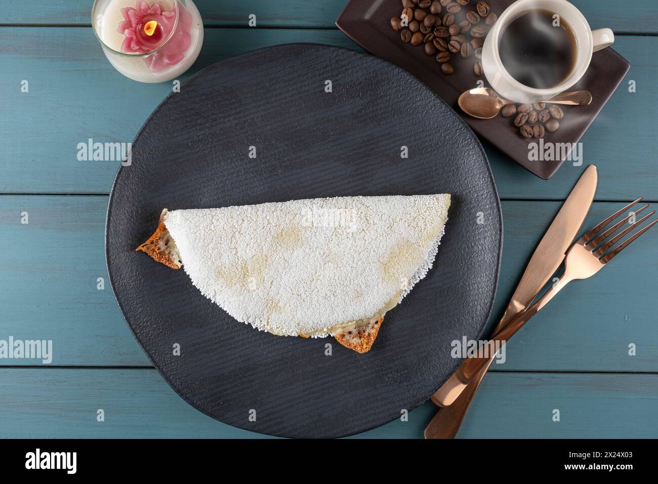 Melted mozzarella cheese tapioca, next to a cup of black coffee blue ...